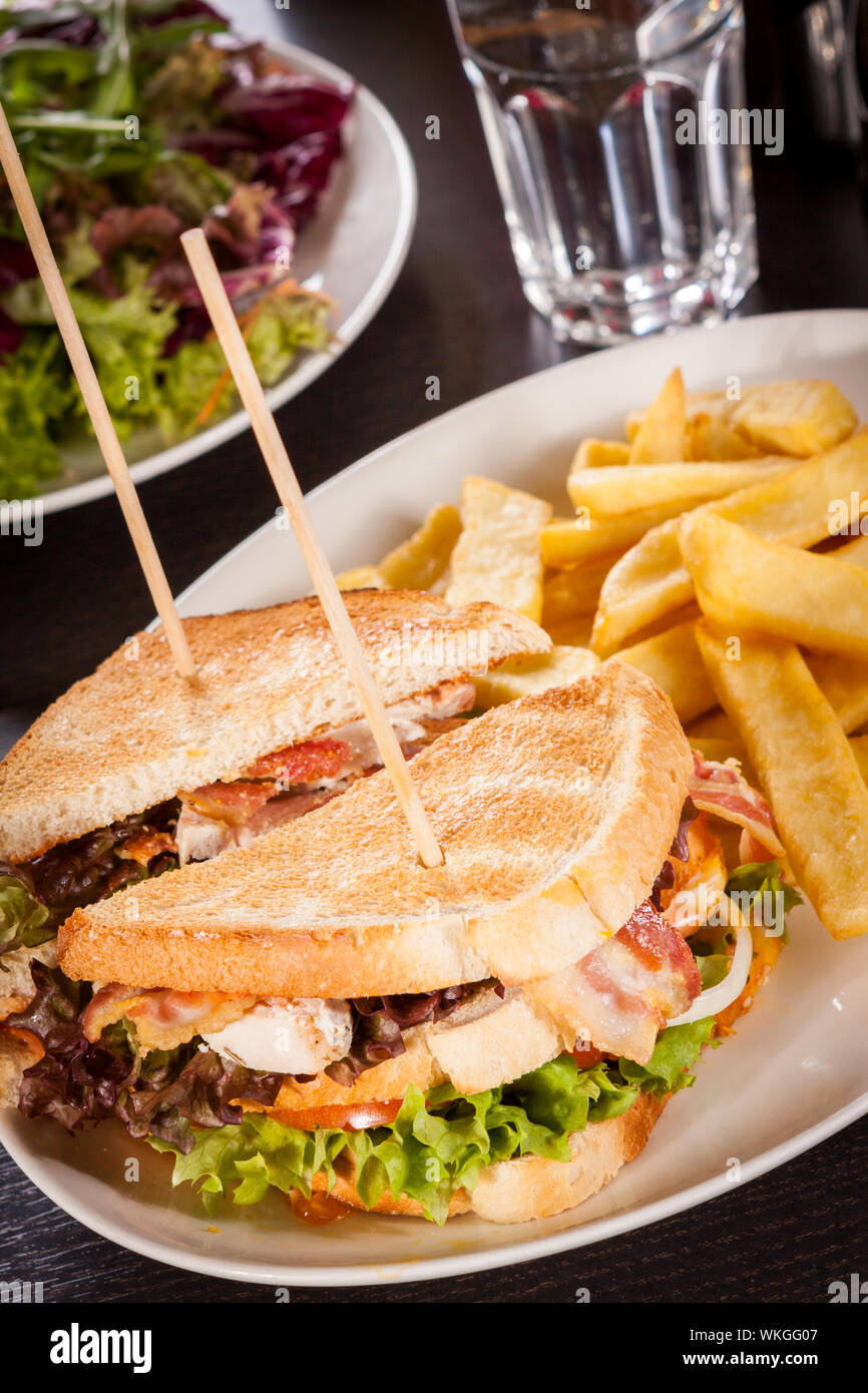 Club sandwich on toasted white bread with a meat filling served with ...