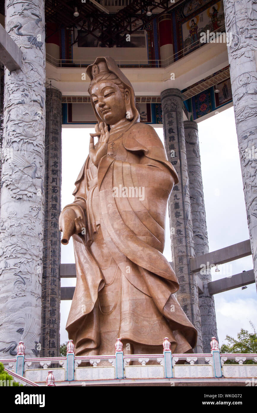 Interior of an ornate Asian temple with statues f deities in recesses ...