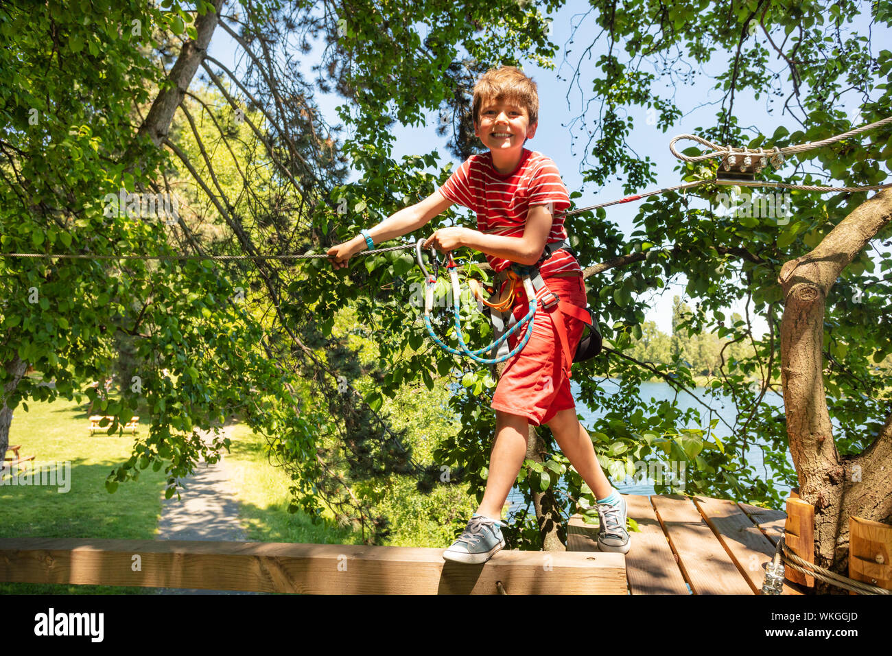 Boy walk on bridge in the trees at adventure park Stock Photo - Alamy