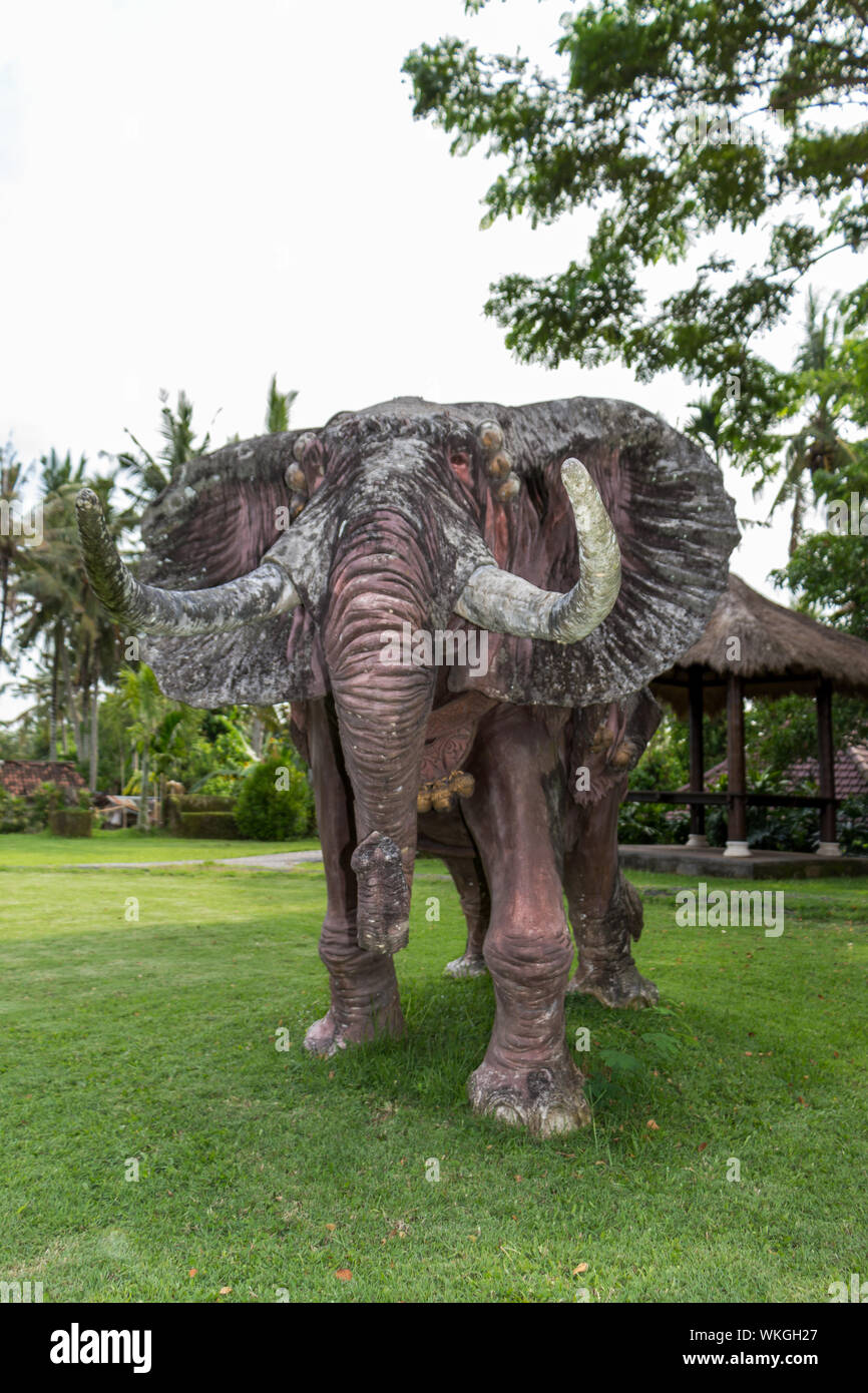 Realistic naturalistic elephant statue standing on a lawn at a park or ...