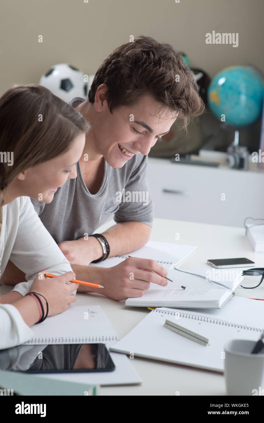 Teen boy and girl sitting together and studying Stock Photo - Alamy