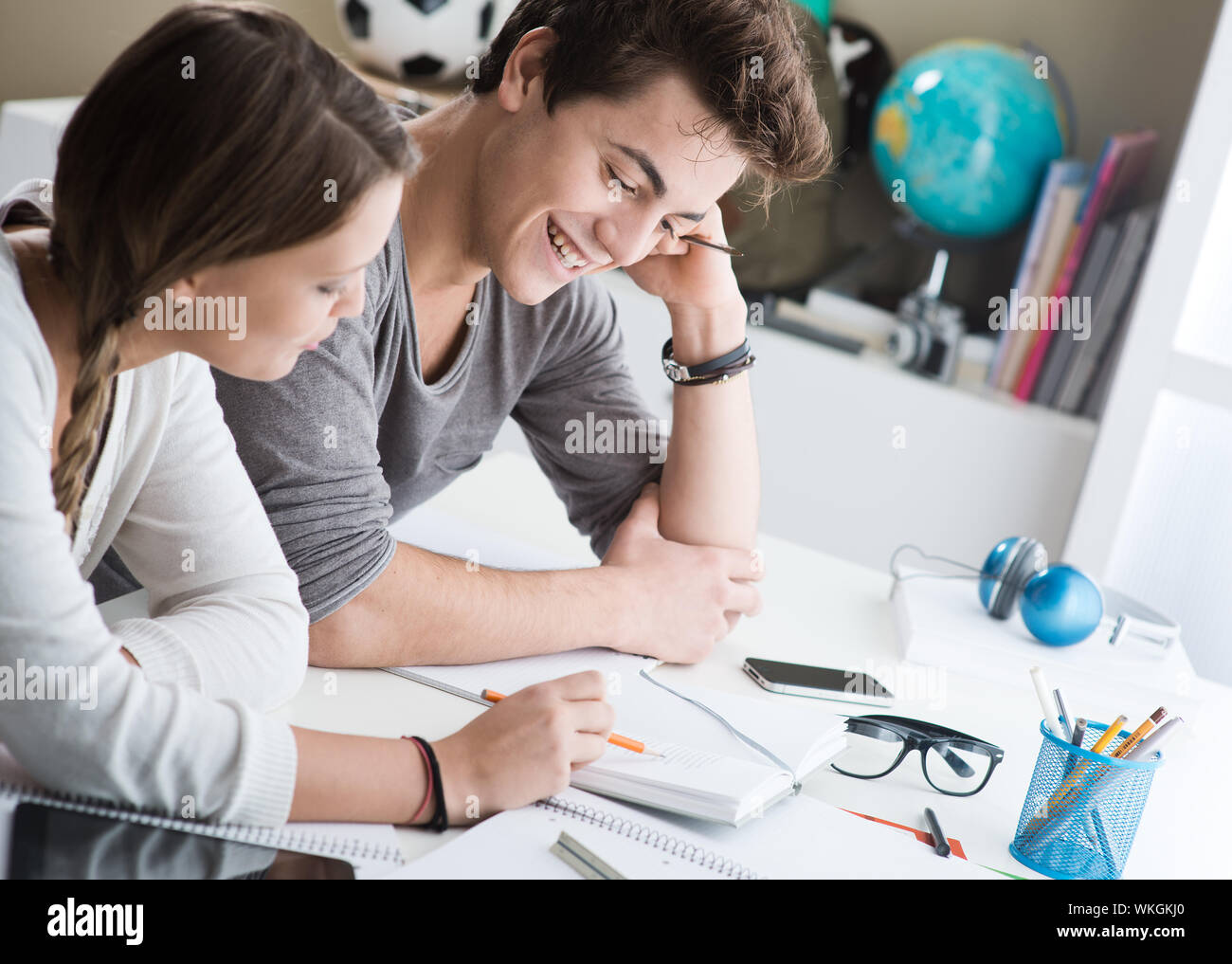 Teen boy and girl sitting together and studying Stock Photo - Alamy
