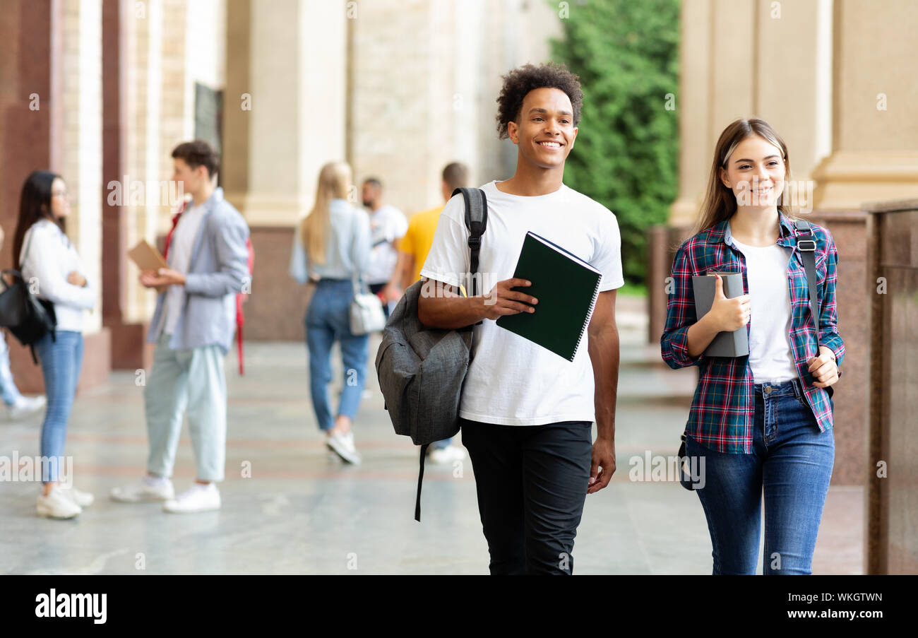 Multiracial students walking in university hall outdoors Stock Photo ...