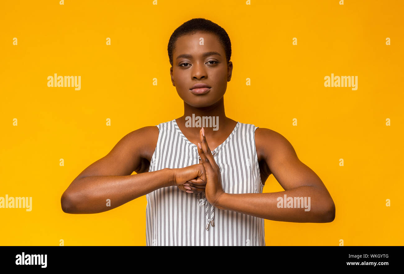 Serious african american woman showing lock sign Stock Photo - Alamy
