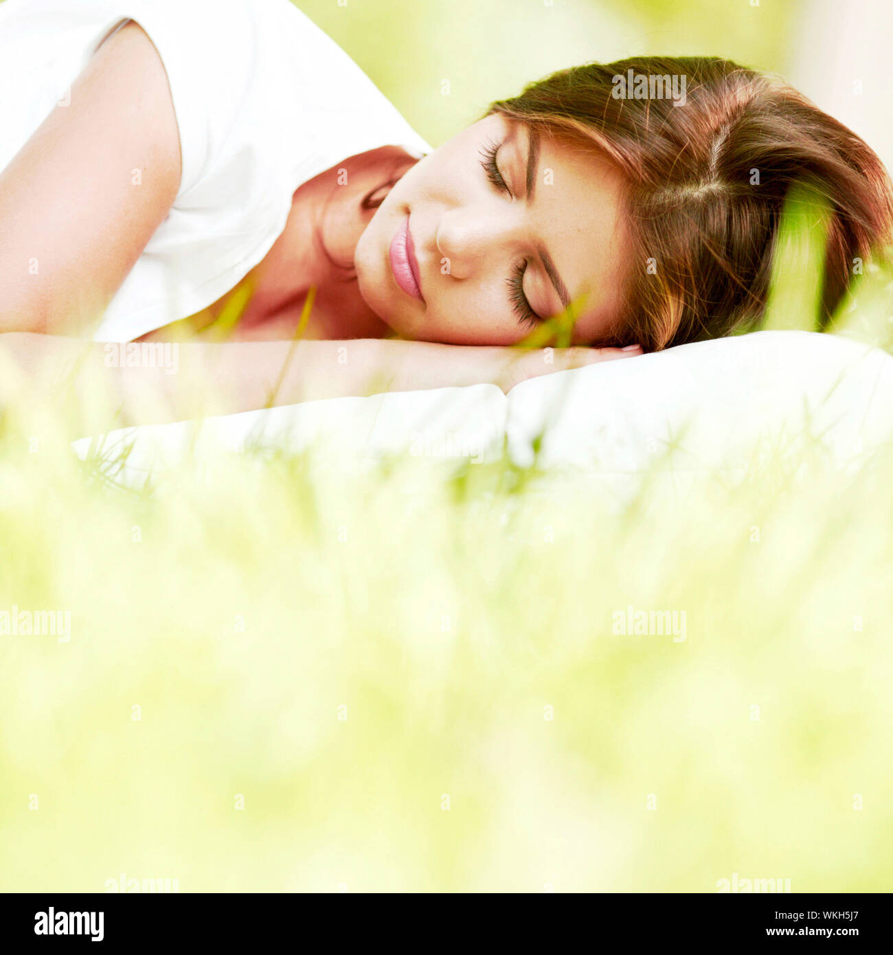 Beautiful young woman sleeping on grass outdoors Stock Photo - Alamy