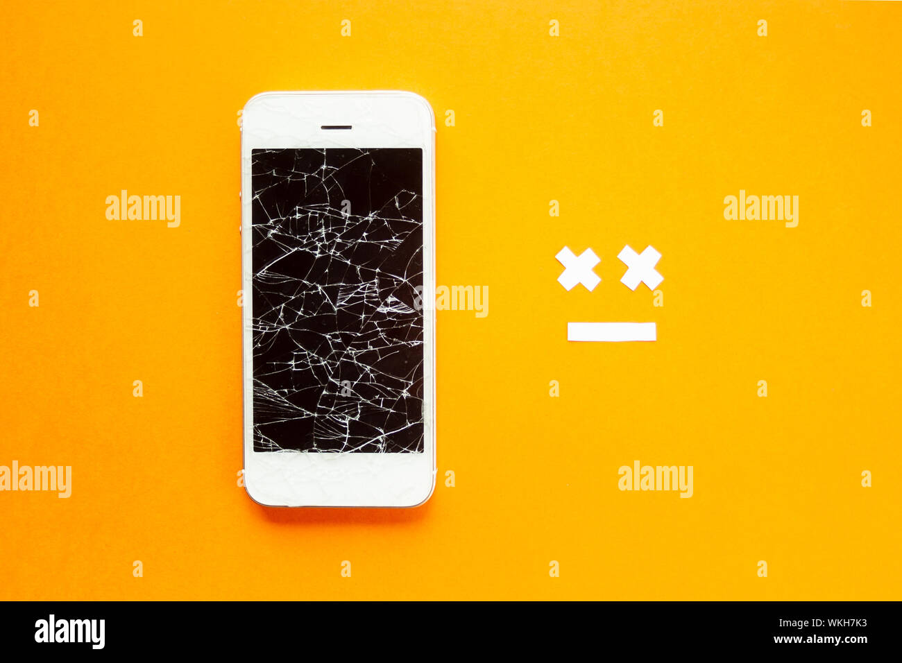 Broken smartphone with cracked destroyed screen on orange background ...