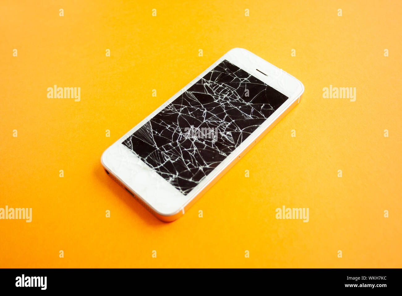 Broken screen of smartphone on the orange background. Smashed glass of ...