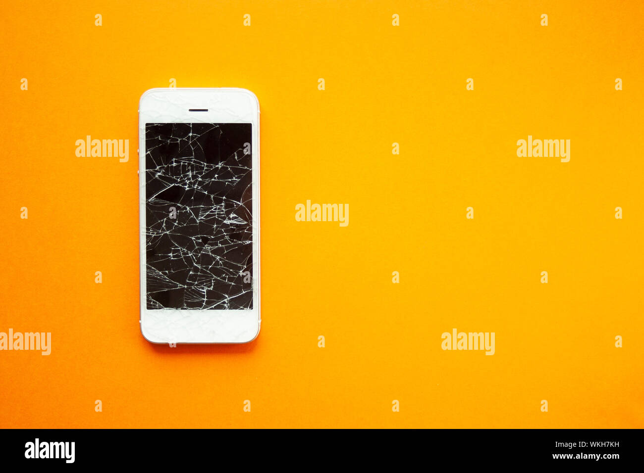 Broken screen of smartphone on the orange background. Smashed glass of ...
