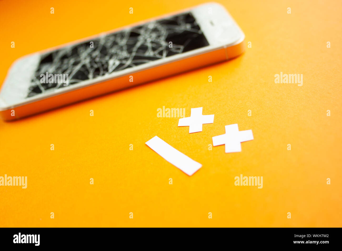 Broken smartphone with cracked destroyed screen on orange background ...