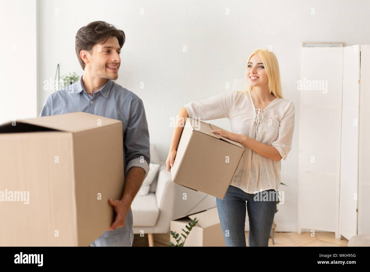 Happy Man And Woman Carrying Moving Boxes Entering New Flat Stock Photo ...