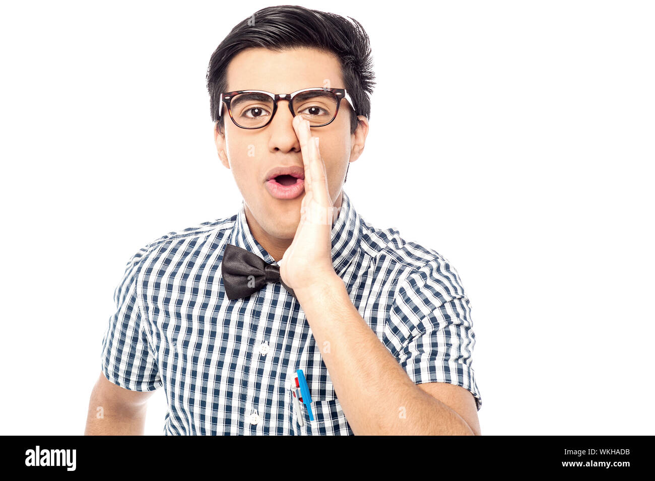 Handsome young man holding hand near open mouth gesture Stock Photo - Alamy