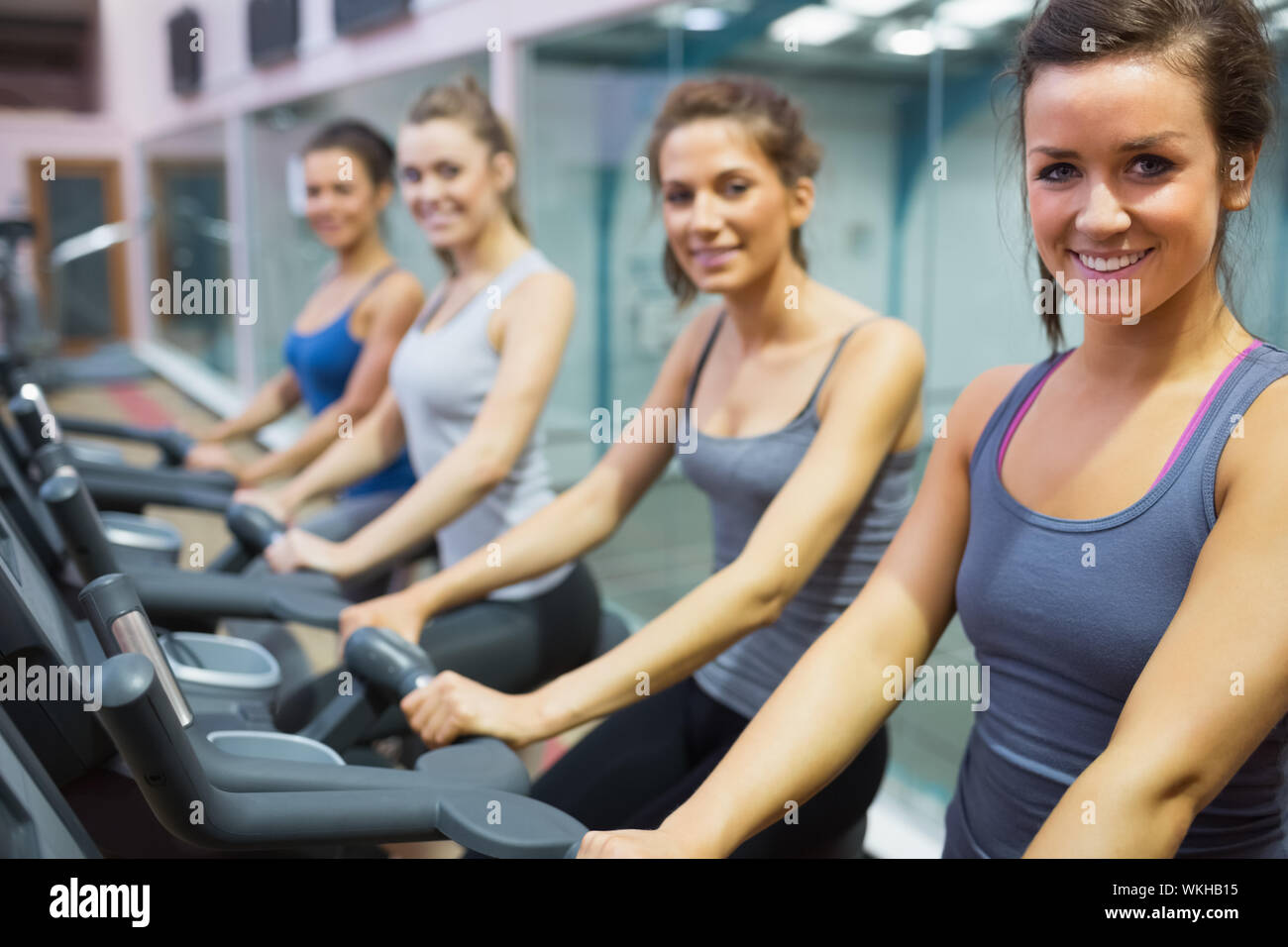 Four smiling women at spinning class in gym Stock Photo - Alamy