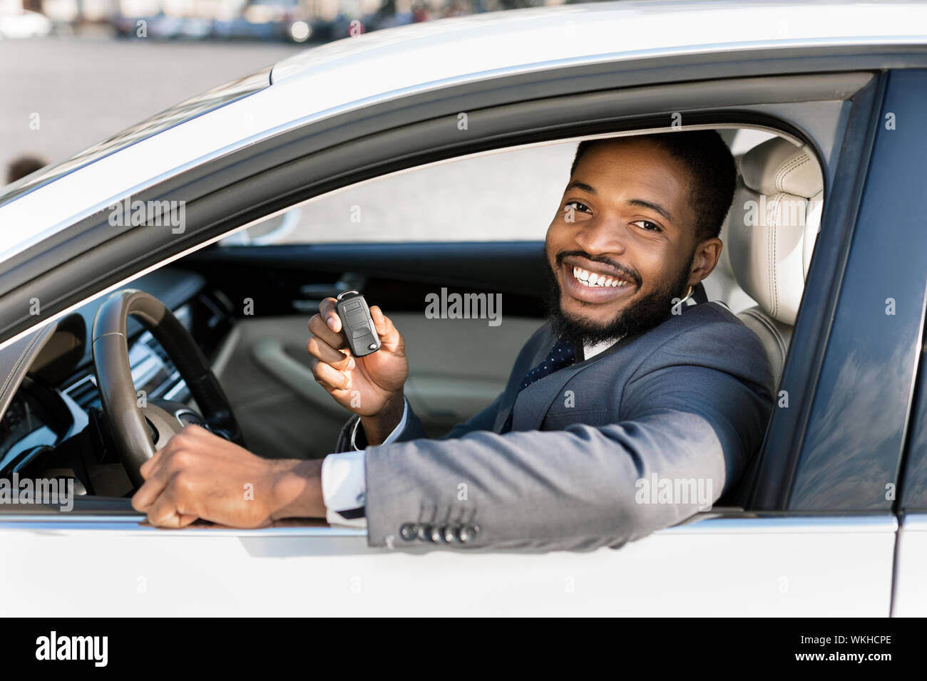 Happy customer just bought new auto at car dealership Stock Photo - Alamy