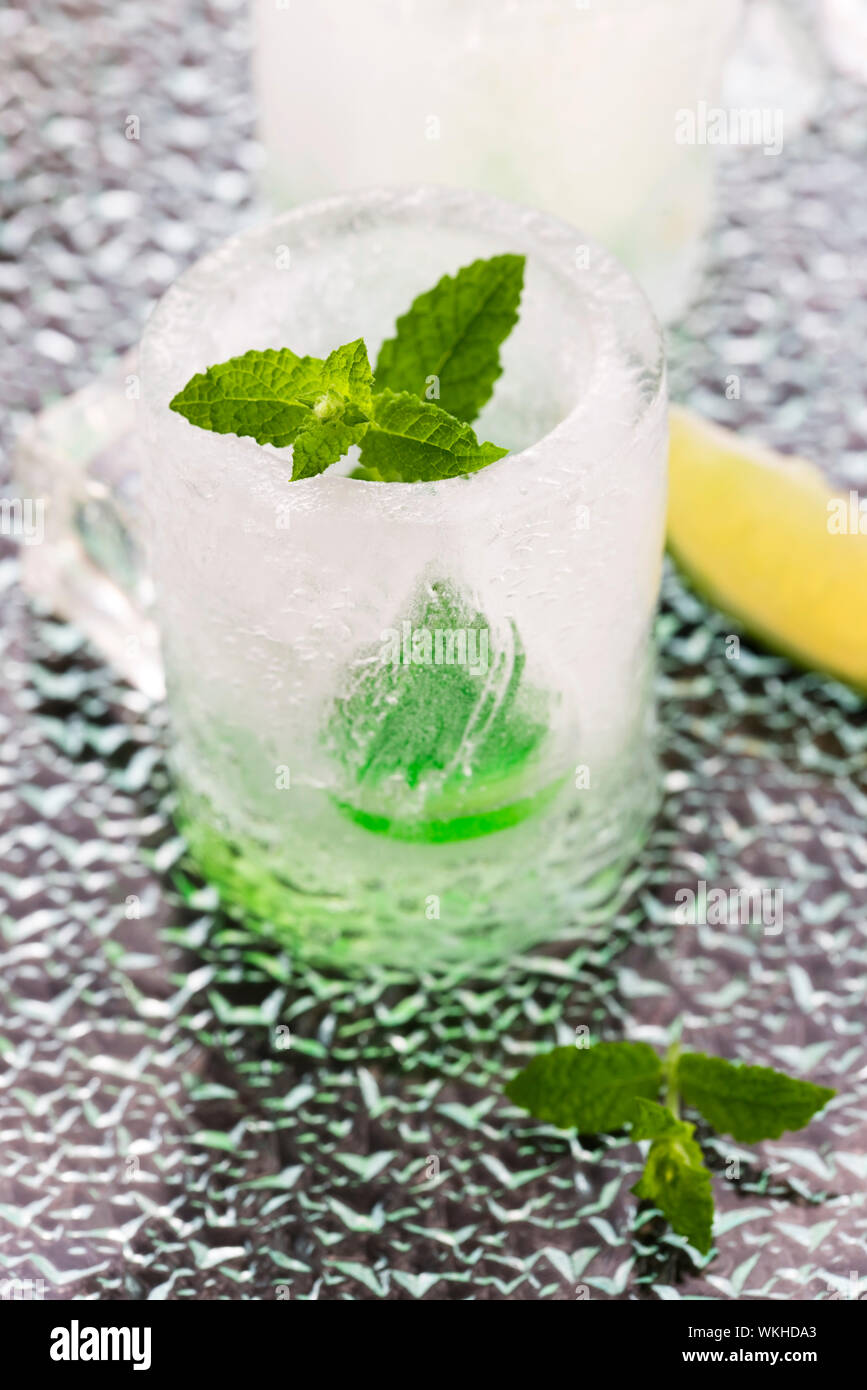 glass made of ice with vodka, lemon and mint Stock Photo - Alamy