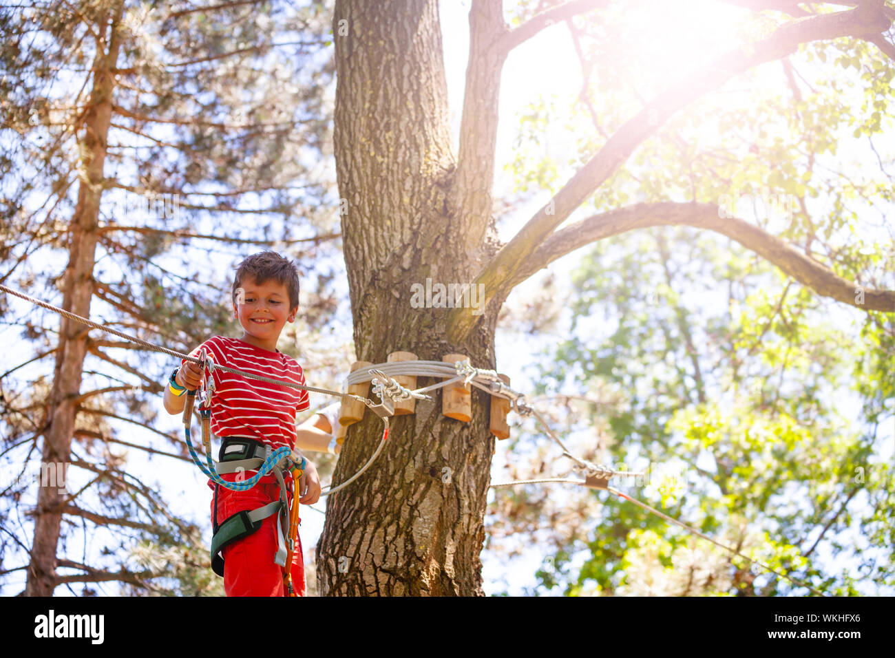 Boy on the rope park line attached to cable Stock Photo - Alamy