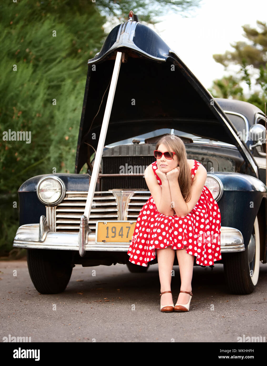 Pretty girl with engine failure on vintage sedan Stock Photo - Alamy
