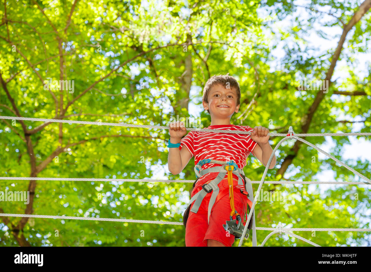 Portrait of a boy on rope climbing line hold cable Stock Photo - Alamy