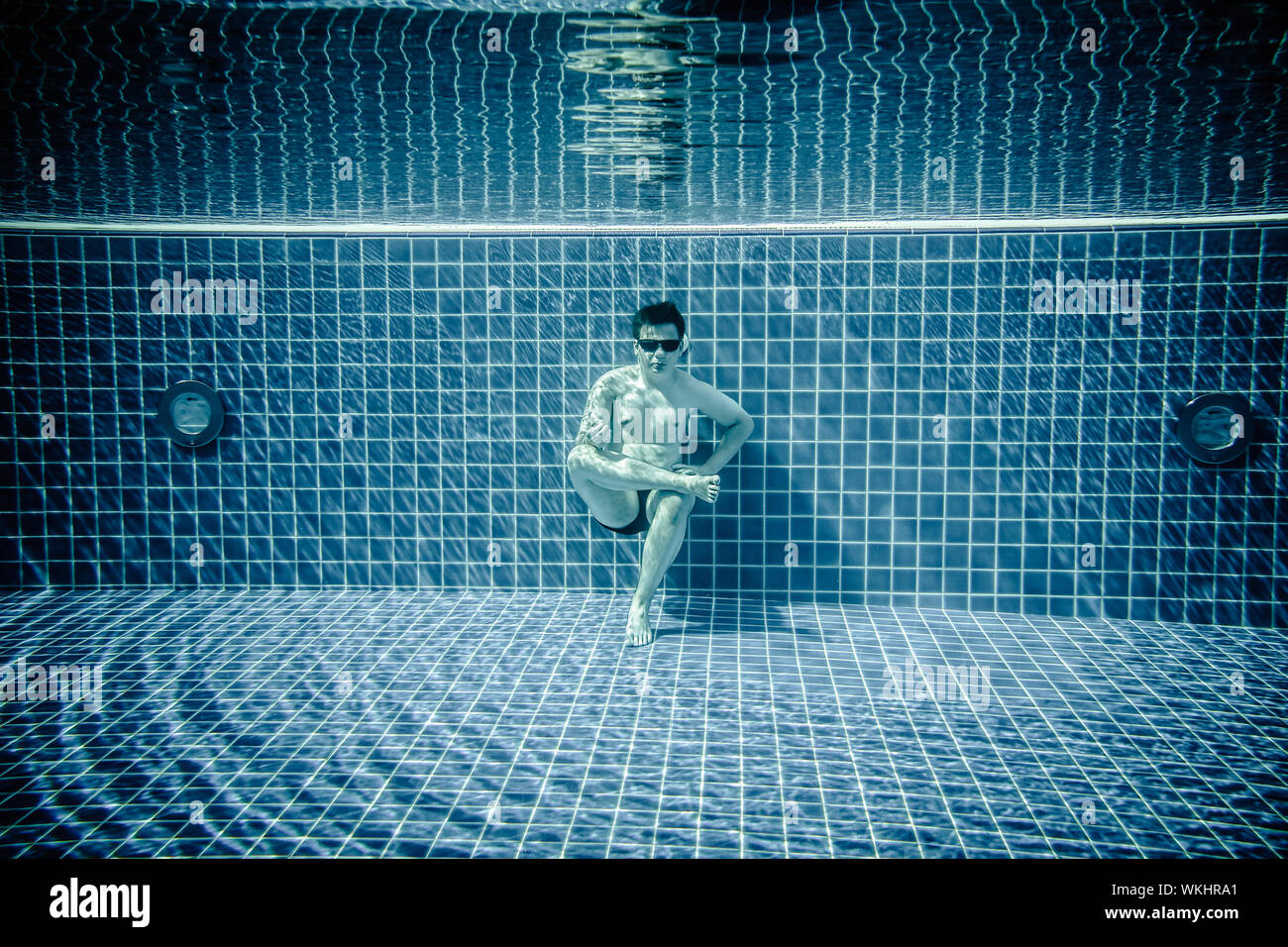 Man sitting on the bottom of the swimming pool under water Stock Photo ...