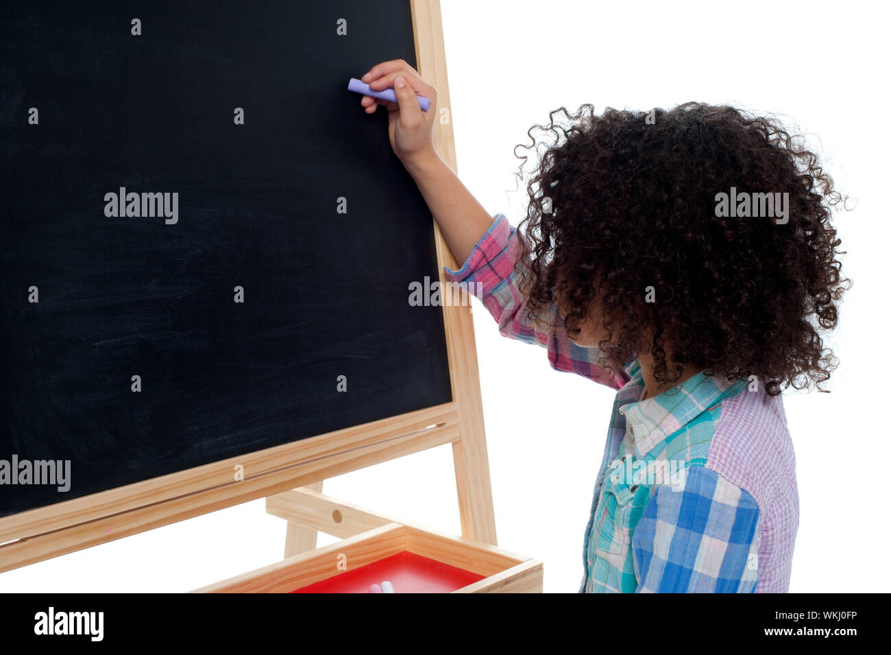 Little girl writing on classroom chalkboard Stock Photo - Alamy