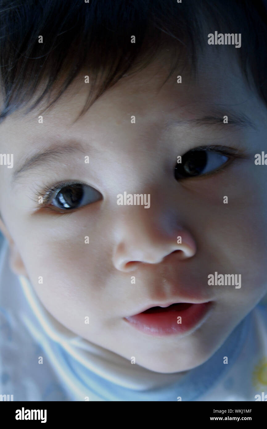 Baby looking up with lovely expression Stock Photo - Alamy