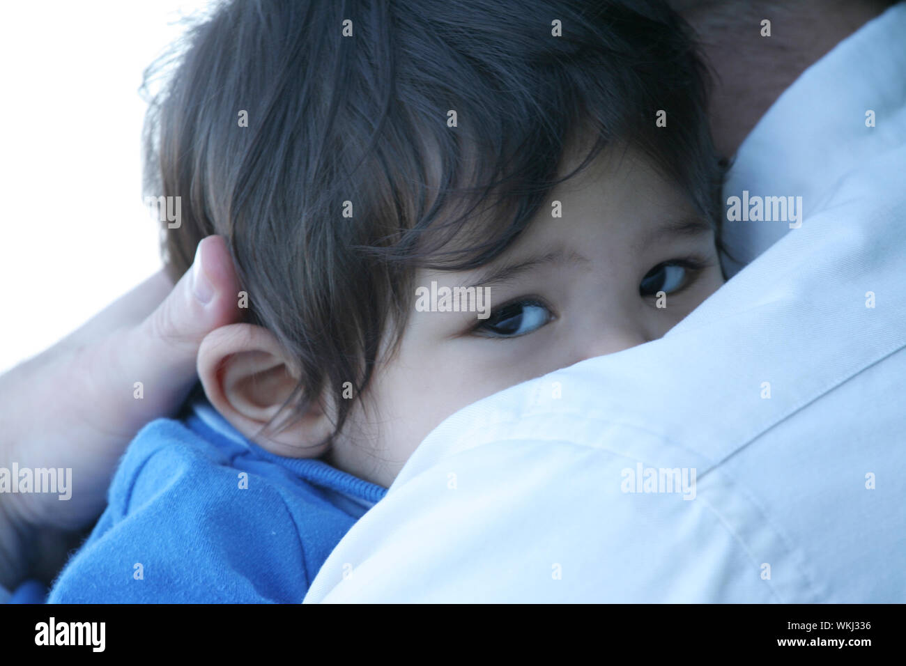 Baby boy snuggled safe in daddy's arms Stock Photo - Alamy
