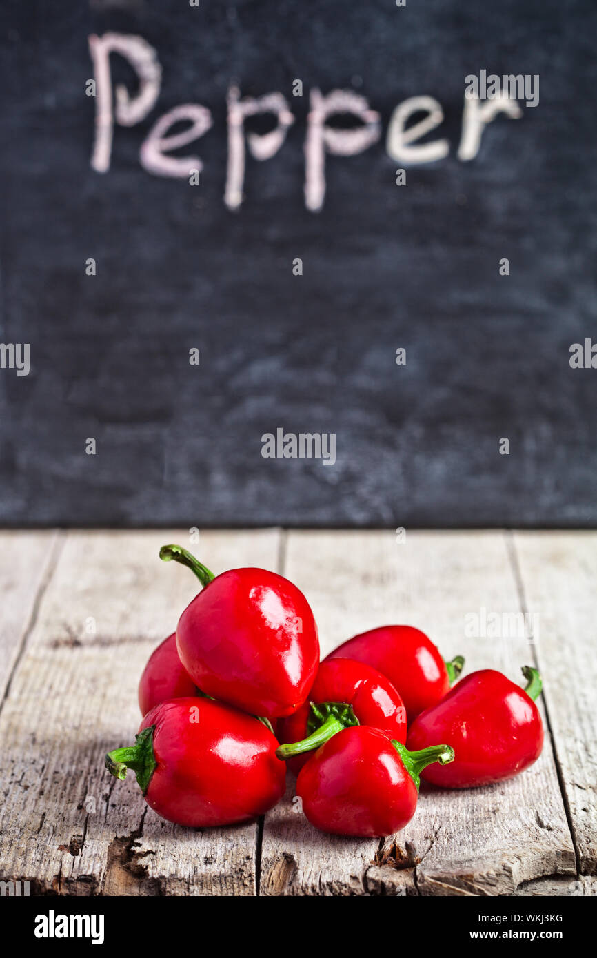 red hot peppers and blackboard on rustic wooden table Stock Photo - Alamy