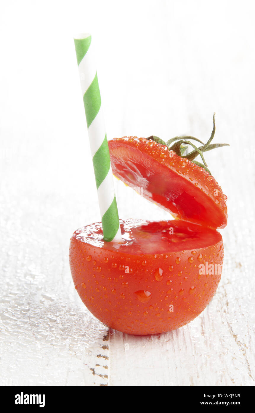 fresh and wet open tomato with straw Stock Photo - Alamy