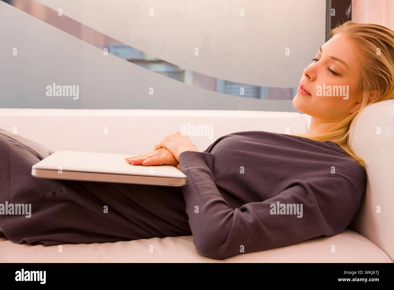 Young woman with laptop sleeping couch Stock Photo - Alamy