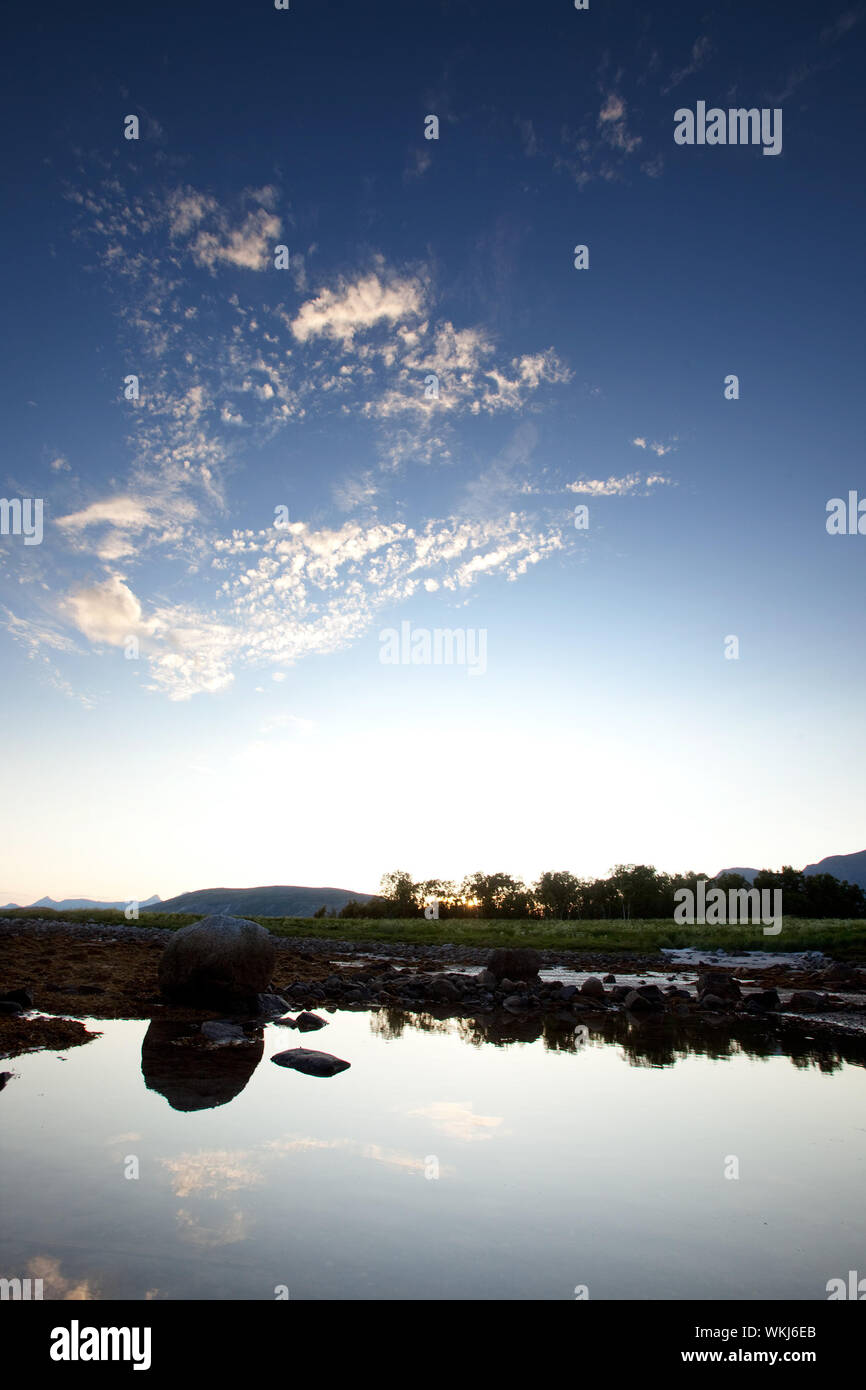 A calm pool of water reflection the landscape behind Stock Photo - Alamy