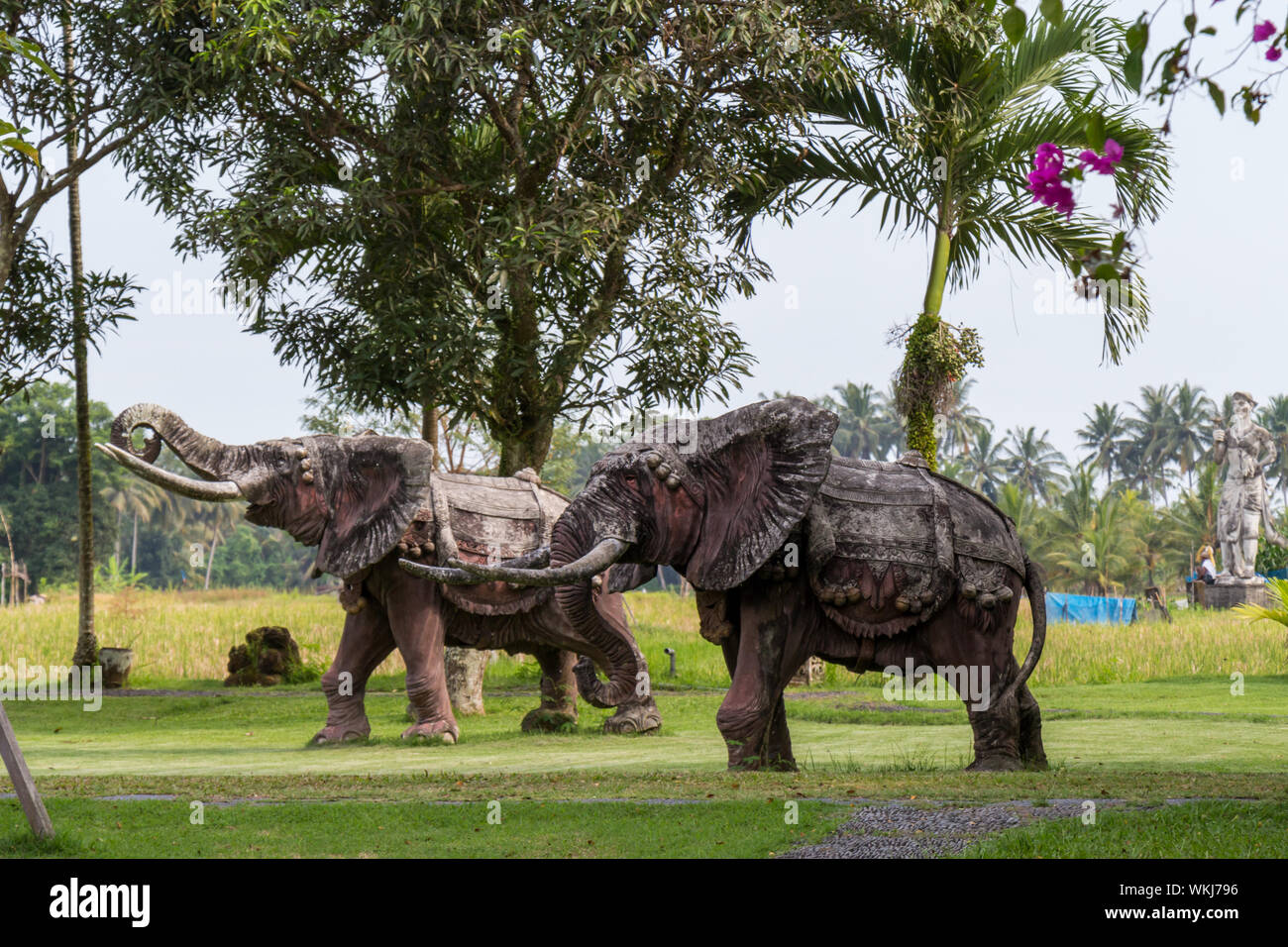 Realistic naturalistic elephant statue standing on a lawn at a park or ...