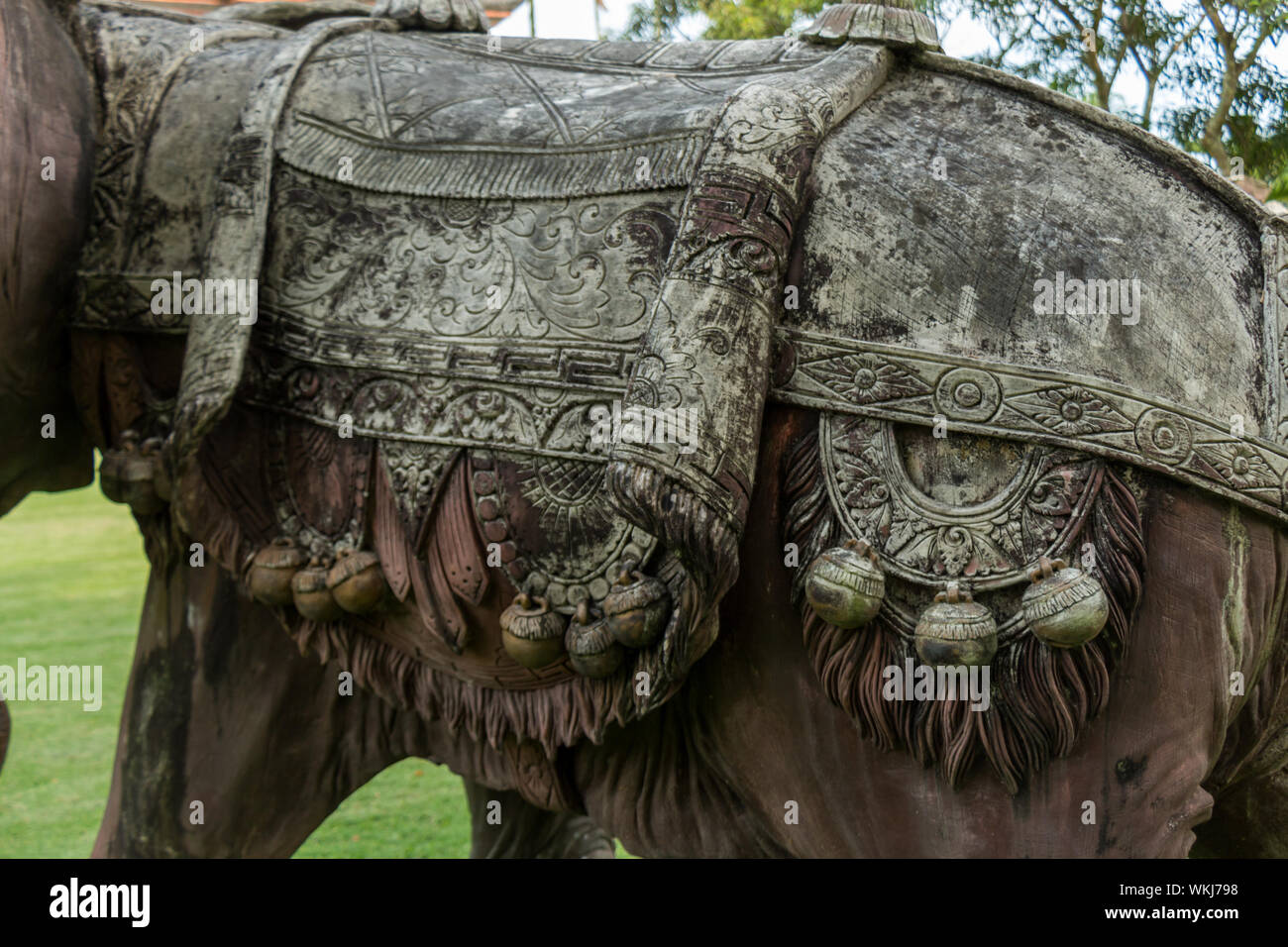 Realistic naturalistic elephant statue standing on a lawn at a park or ...