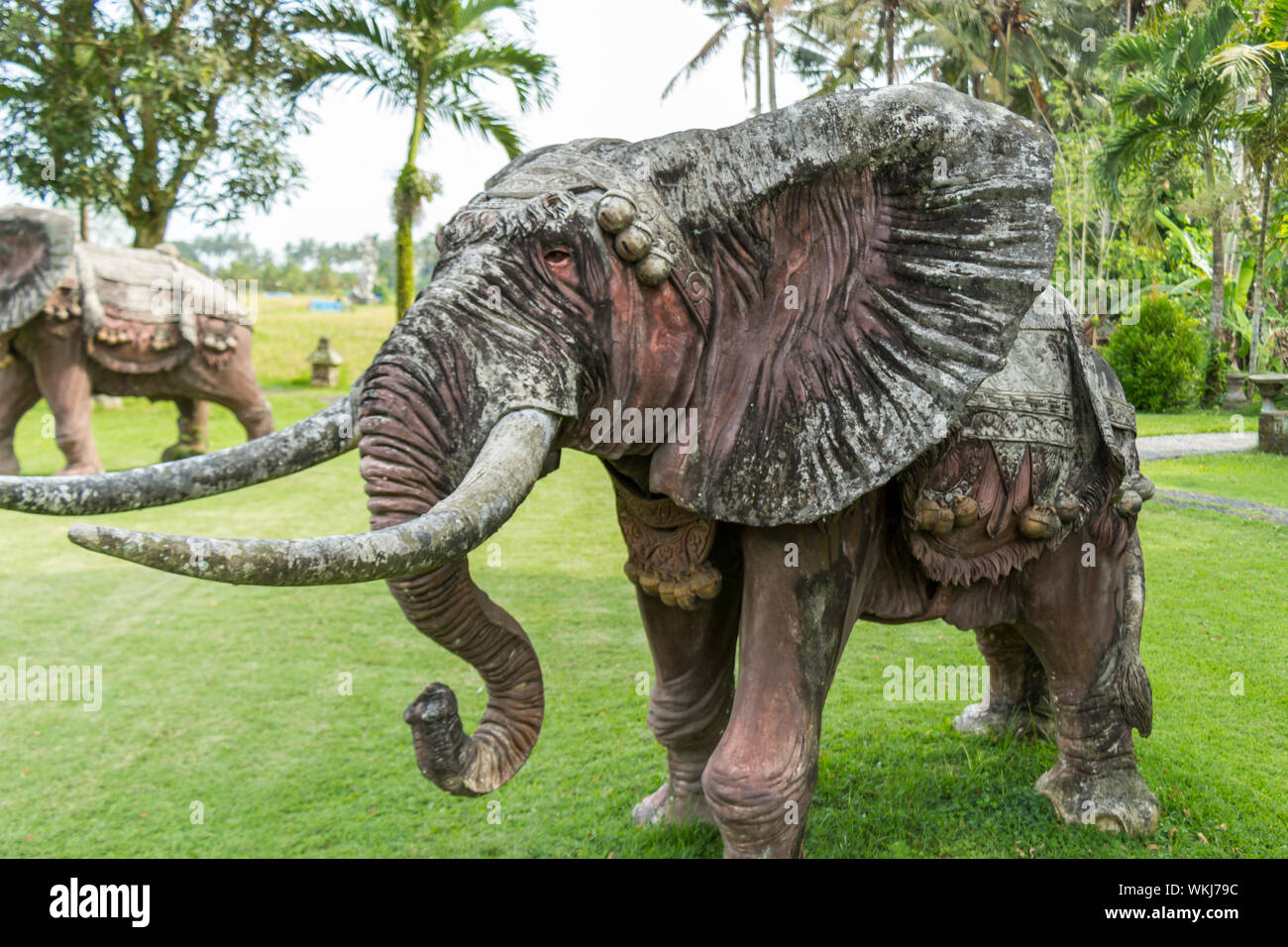 Realistic naturalistic elephant statue standing on a lawn at a park or ...