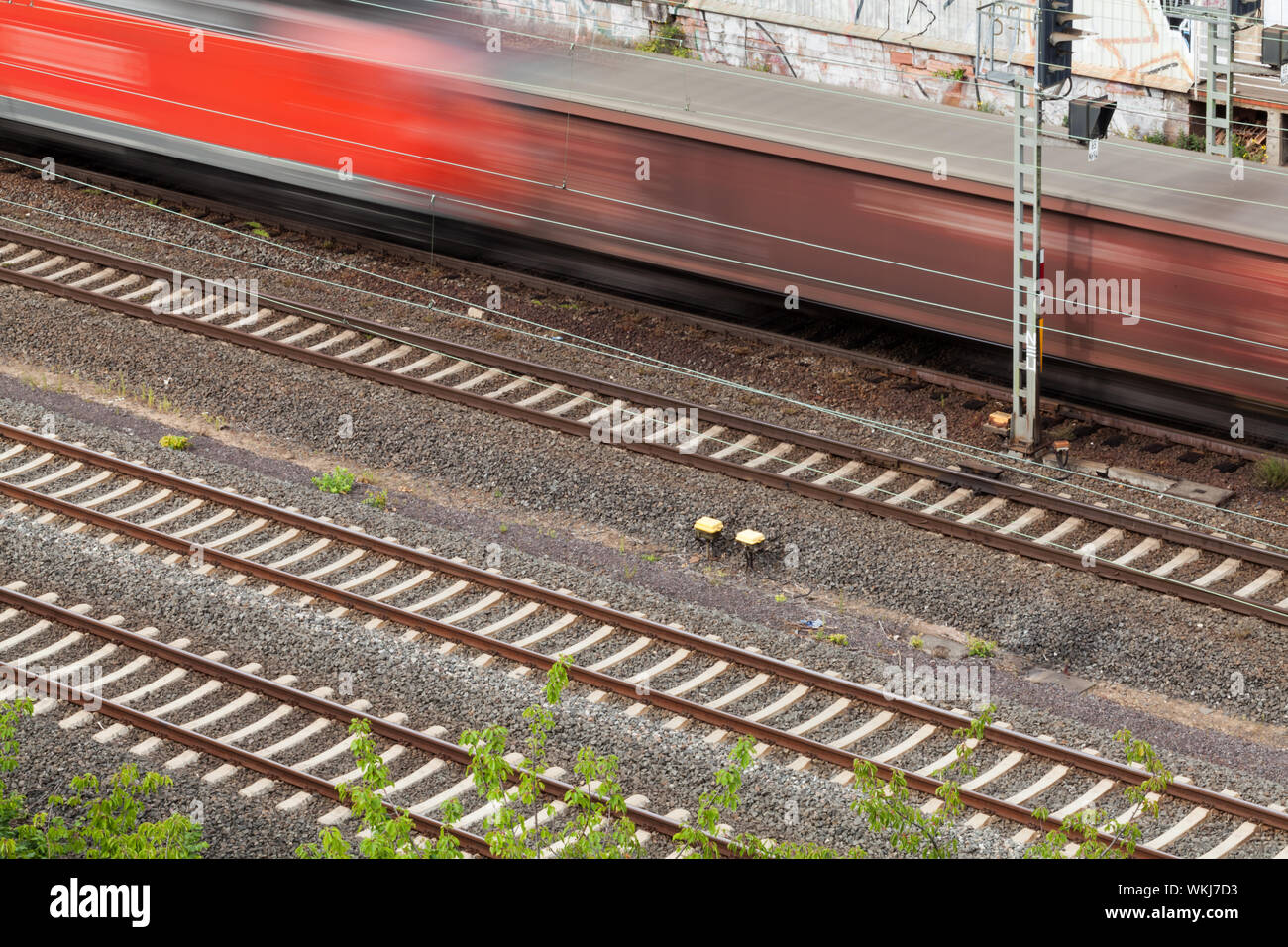 Fast moving train with red stripe passing by Stock Photo - Alamy