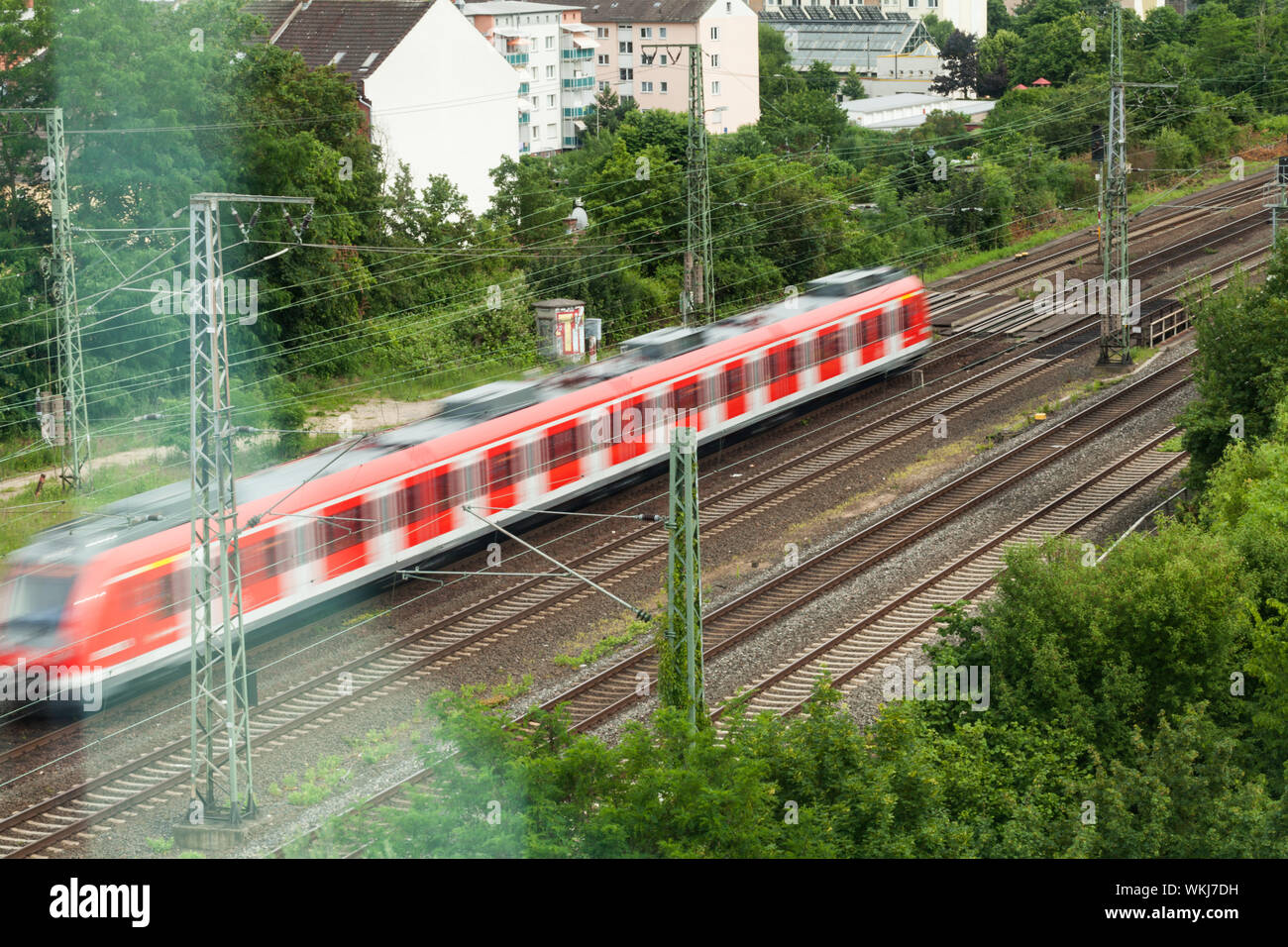 Fast moving train with red stripe passing by Stock Photo - Alamy