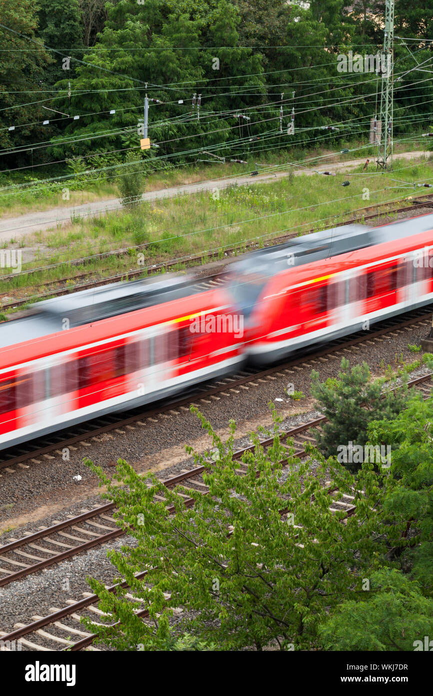 Fast moving train with red stripe passing by Stock Photo - Alamy