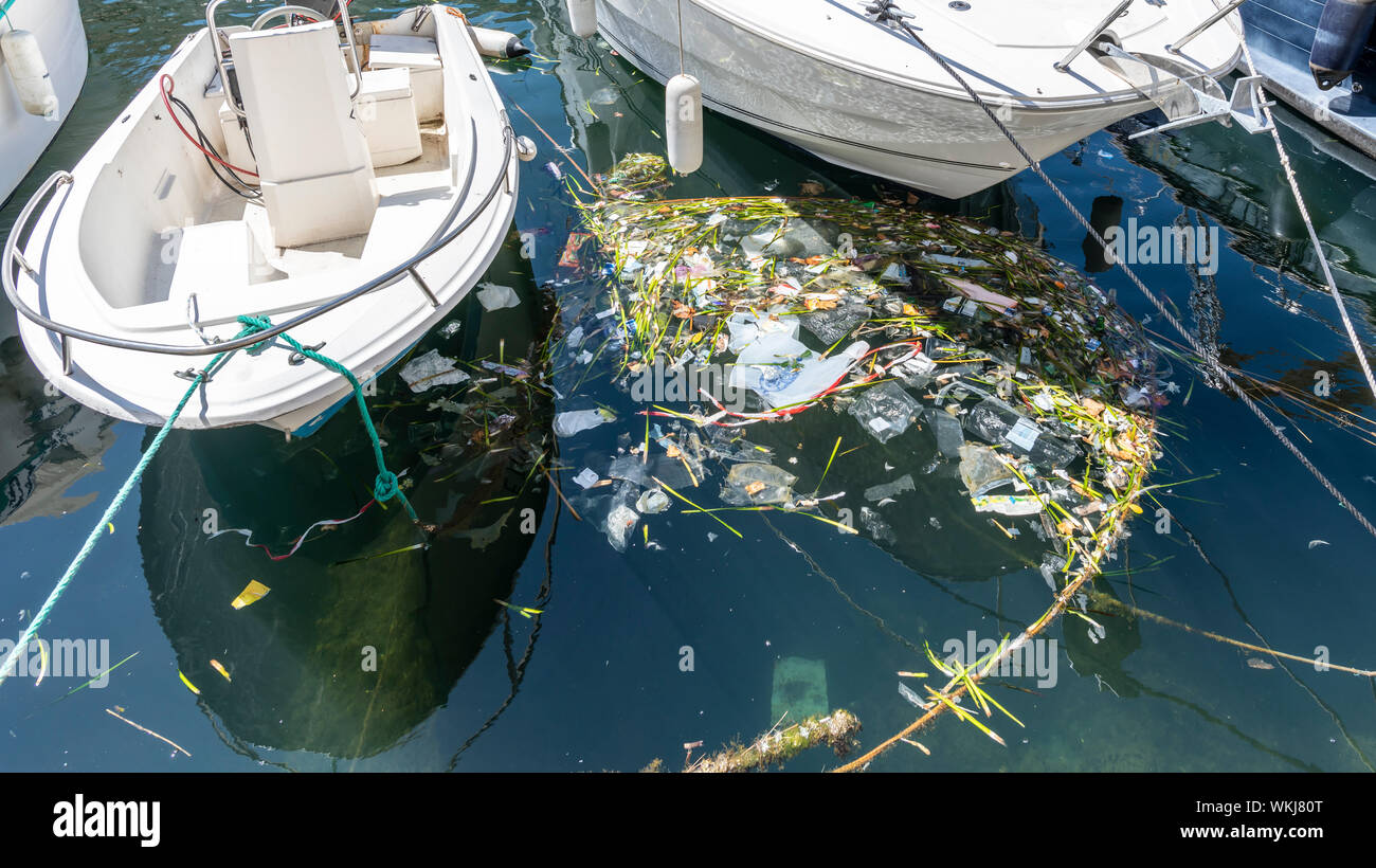 Rubbish, litter debris floating between boats in a marina or a port ...
