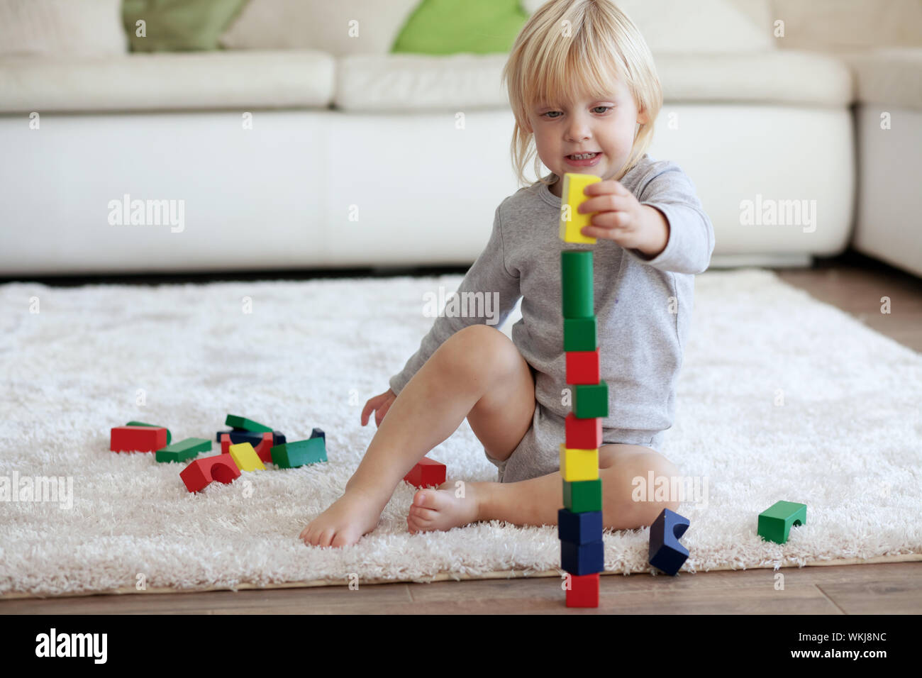Toddler playing with wooden blocks at home Stock Photo - Alamy