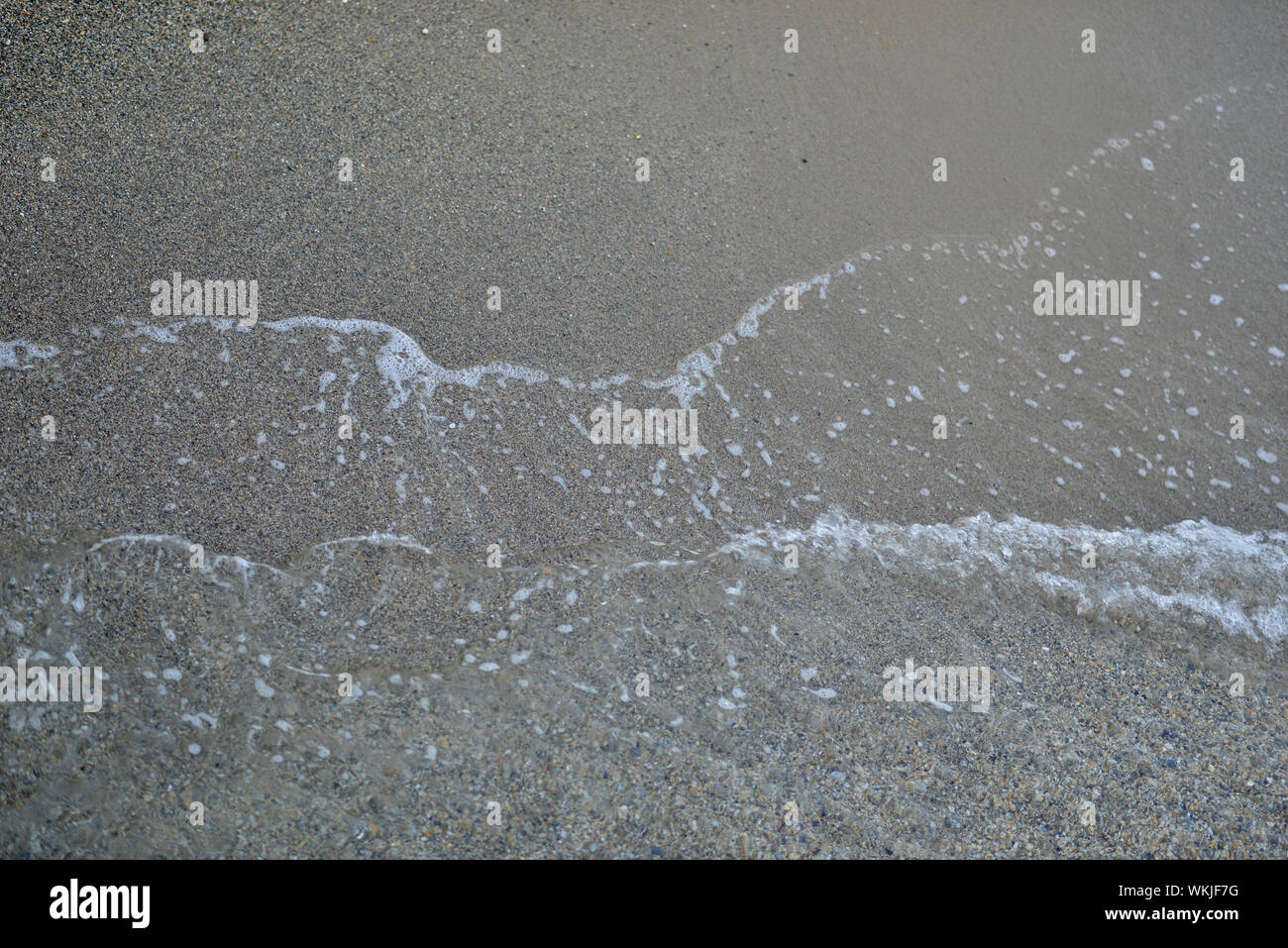 Seawater on the sandy beach. Natural background Stock Photo - Alamy