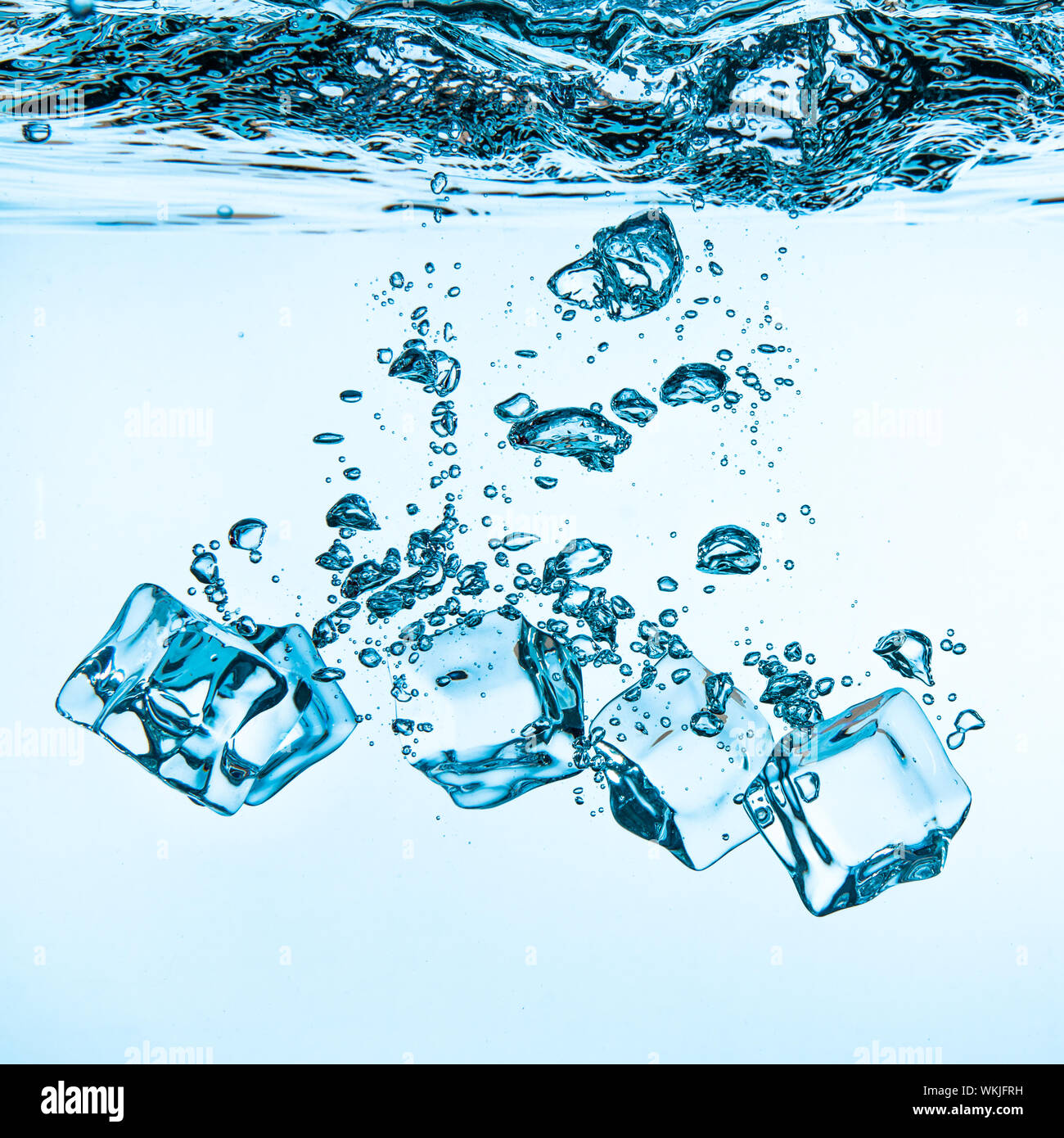 Ice cubes falling into the water sinking to the bottom. Abstract ...
