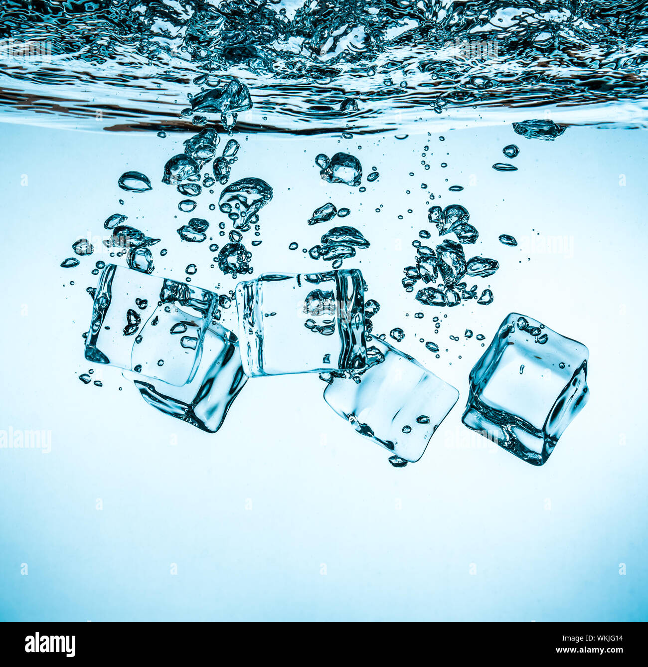 Ice cubes falling into the water sinking to the bottom. Abstract ...