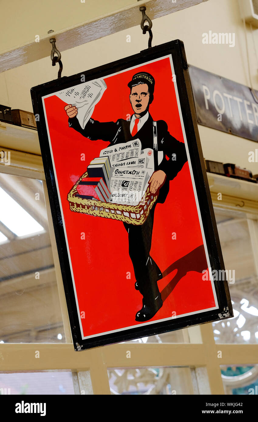 newspaper boy vendor on old railway station poster sign Stock Photo - Alamy