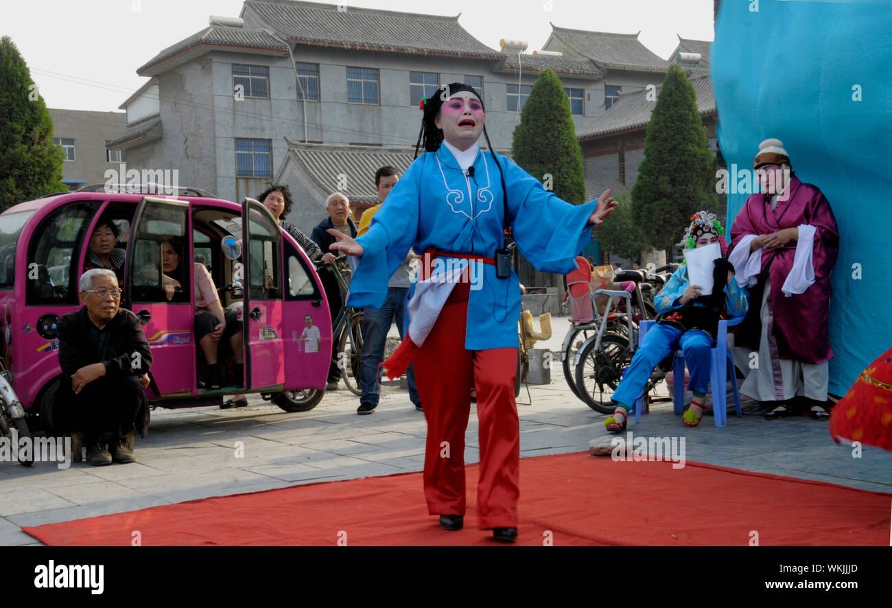 Artists perform during a roadside theatre performance in Louyang, Henan ...