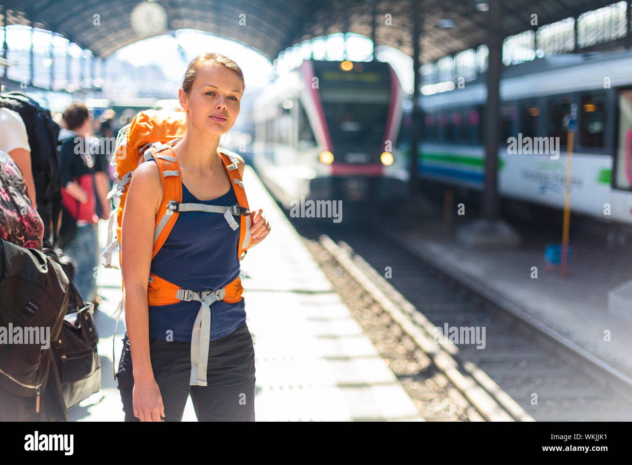 Pretty, young woman in a trainstation, waiting for her train, boarding ...