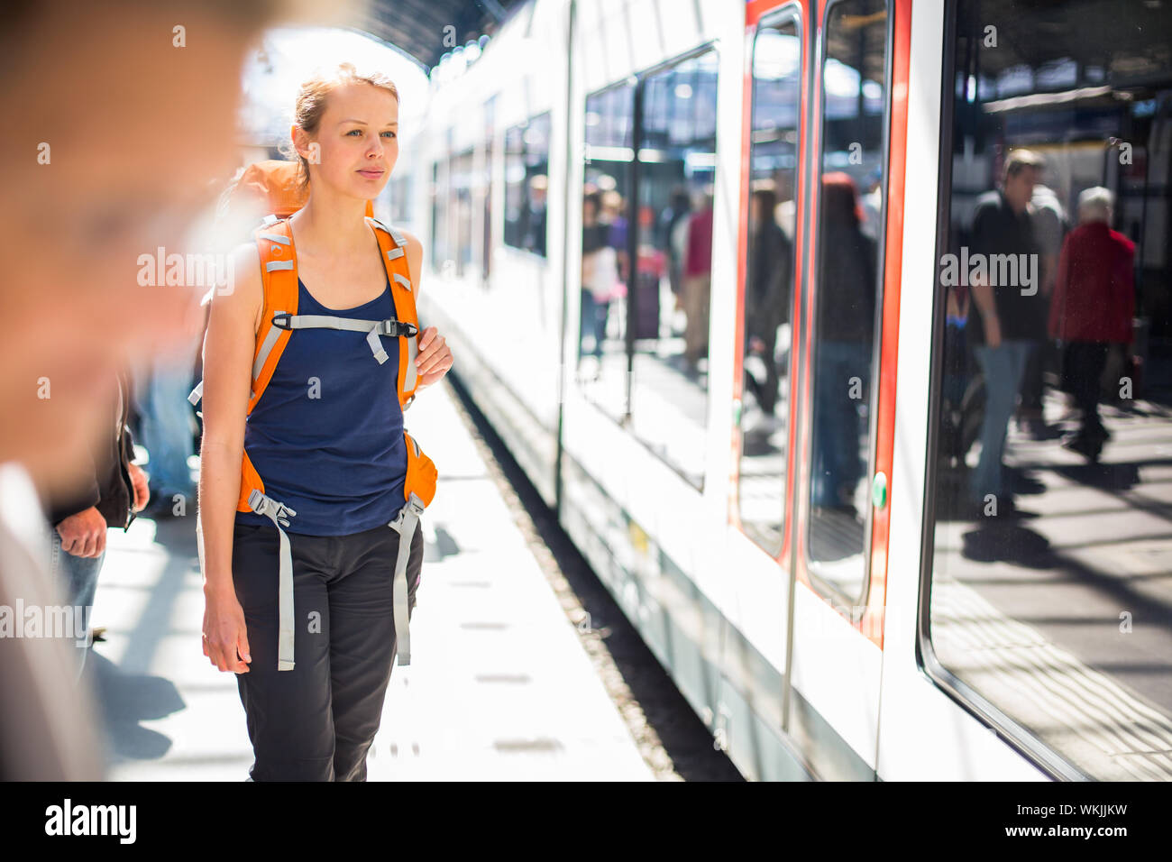 Pretty, young woman in a trainstation, waiting for her train, boarding ...