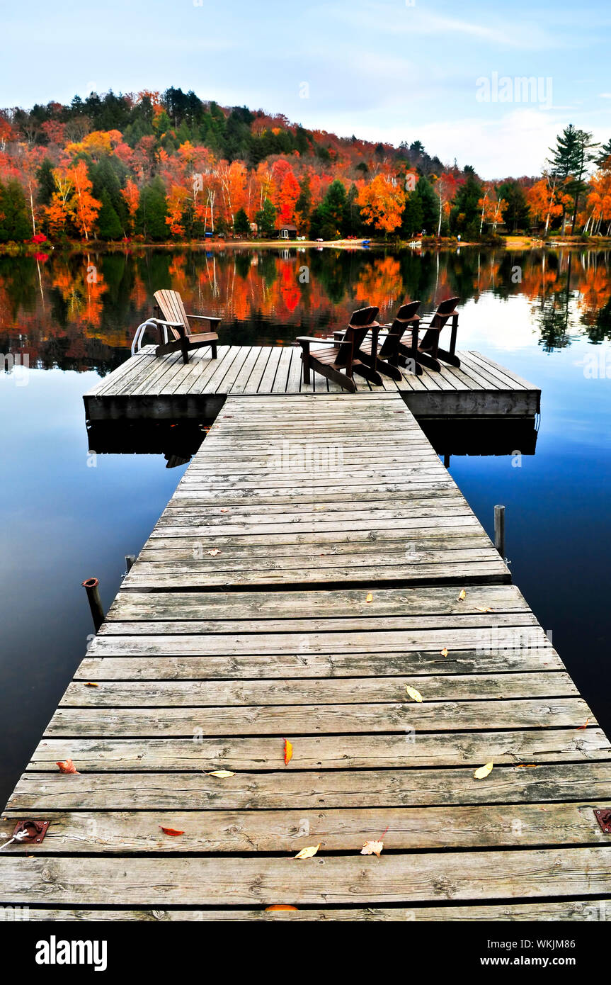 Wooden dock with chairs on calm fall lake Stock Photo - Alamy