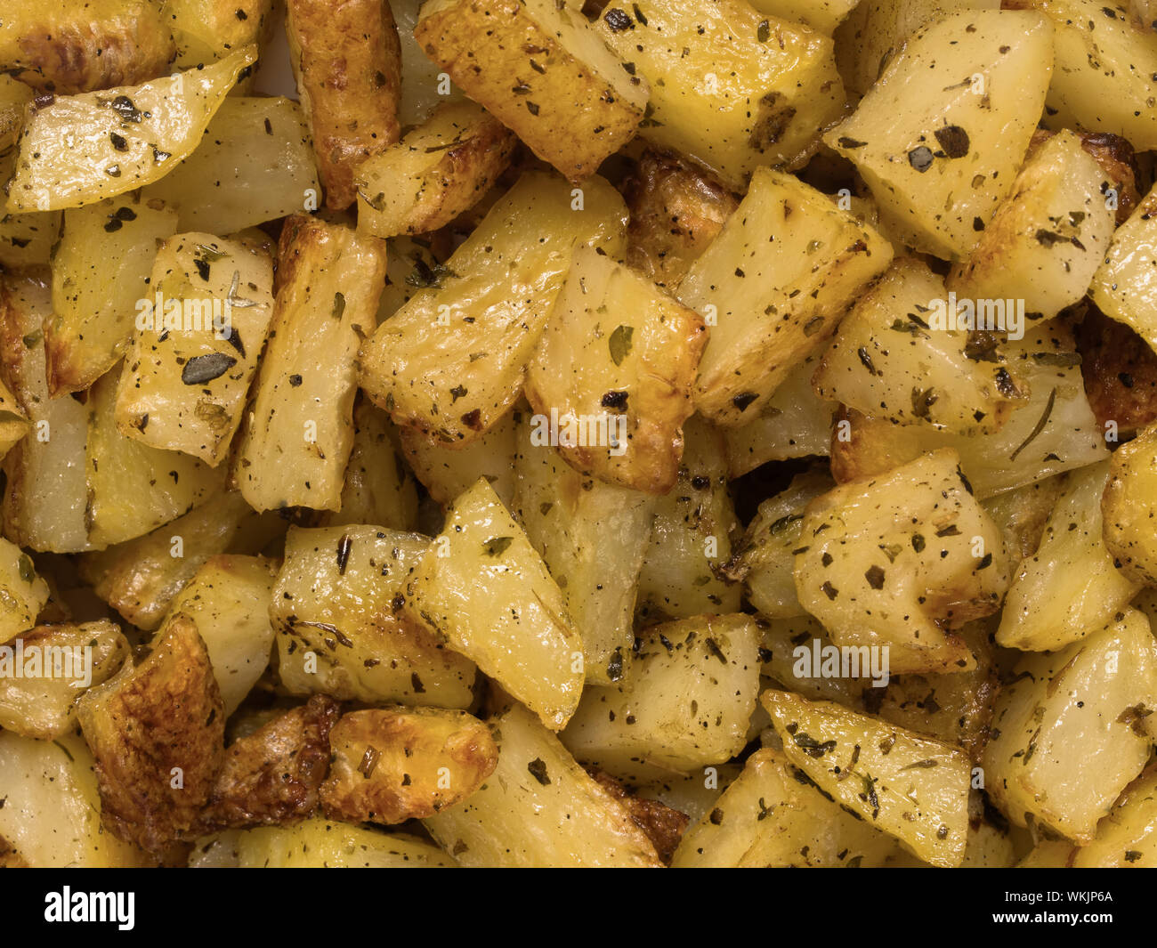 close up of rustic roasted herb potatoes food background Stock Photo ...