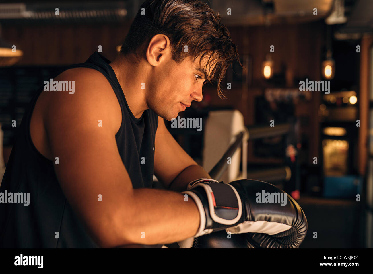 Side view of a tired and exhausted boxer standing in gym Stock Photo ...