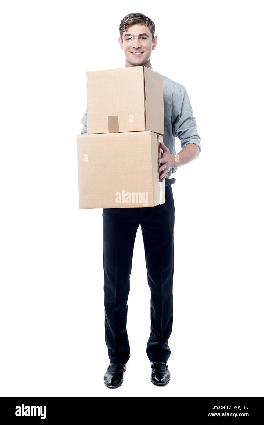 Smiling young corporate man carrying stack of boxes Stock Photo - Alamy