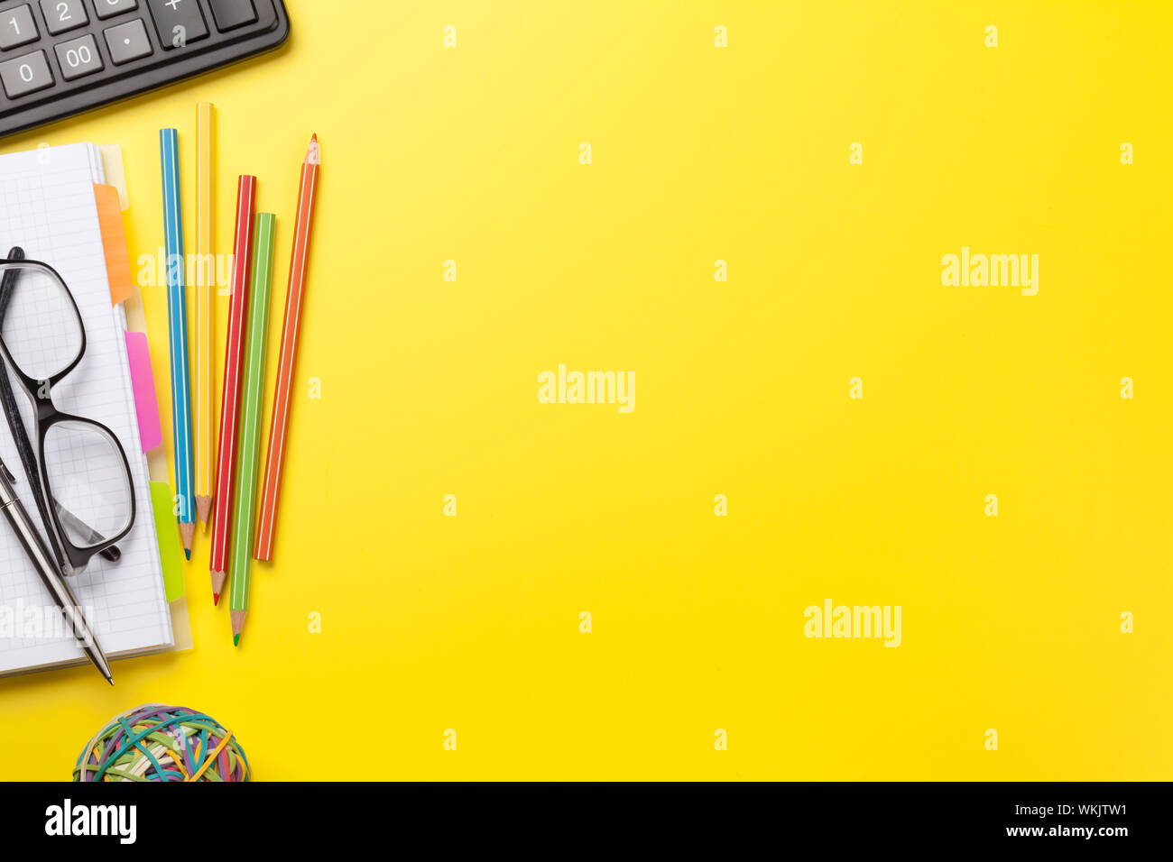 Office yellow workplace backdrop with supplies and glasses. Flat lay ...