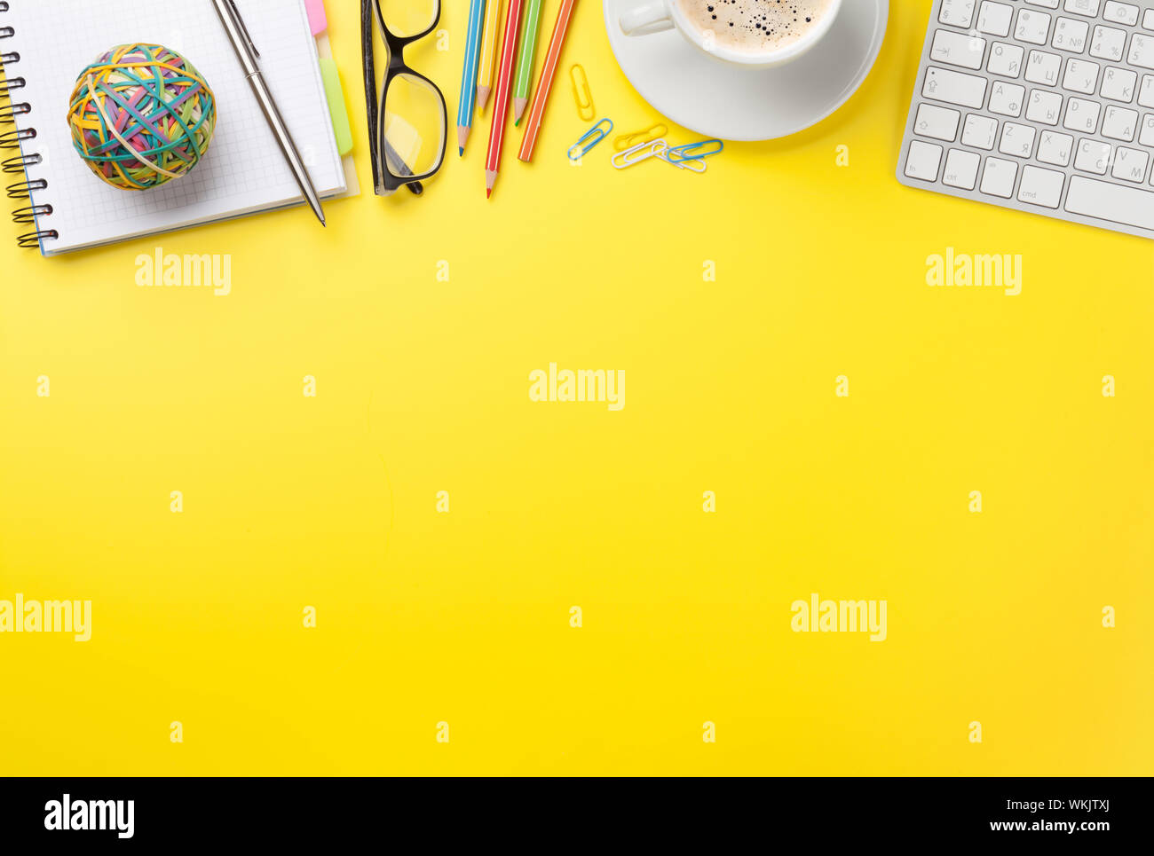 Office yellow workplace backdrop with coffee cup, supplies and computer ...